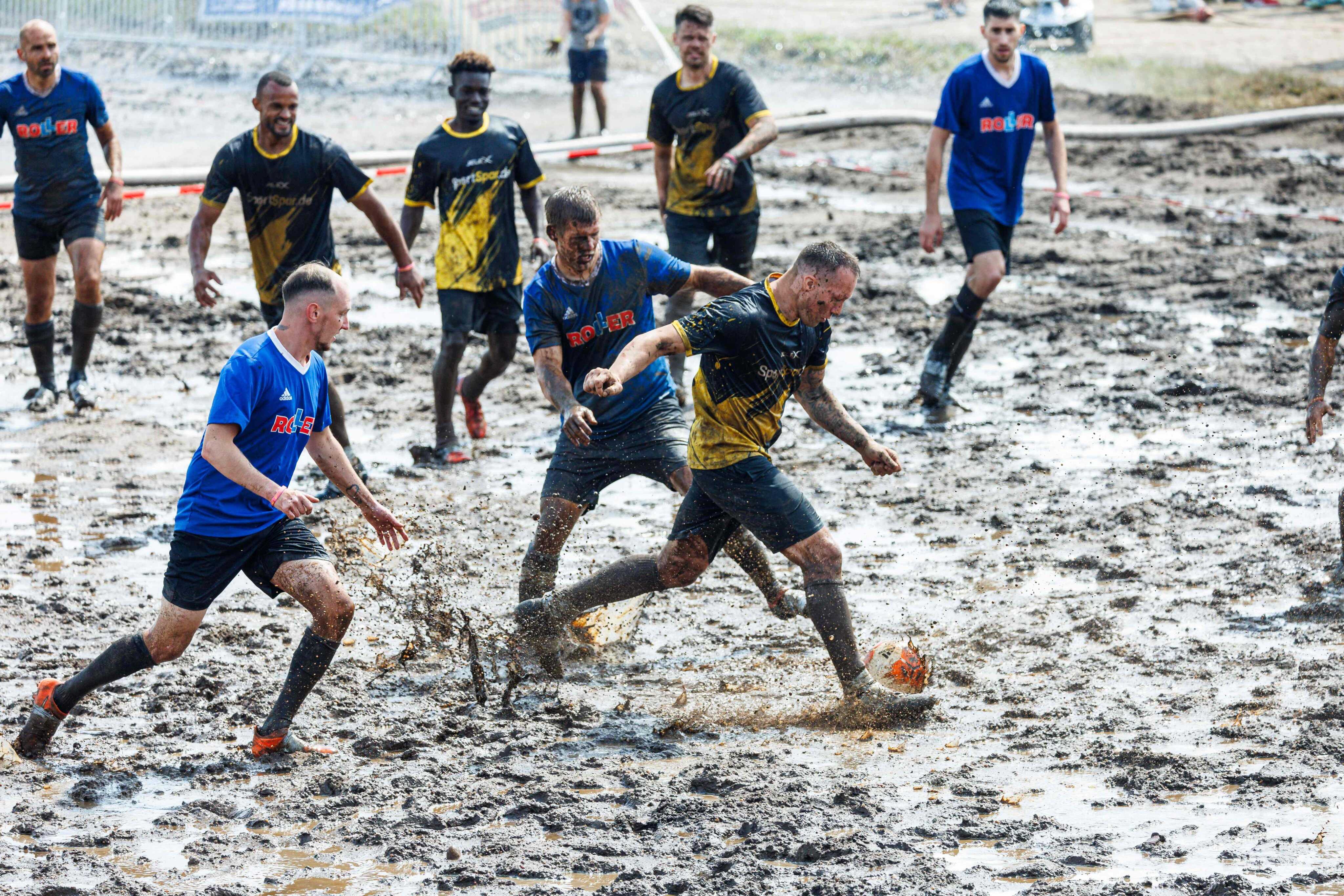 Write a fun caption for participants playing swamp football in the mud ...